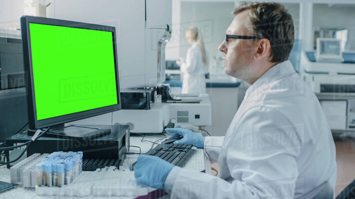 Male Research Scientist Sits at His Workplace in Laboratory, Uses Green ...