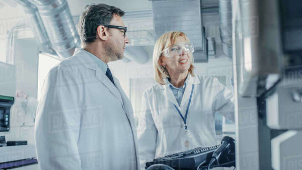 Two Research Scientists Talking about Programming Medical Equipment for ...