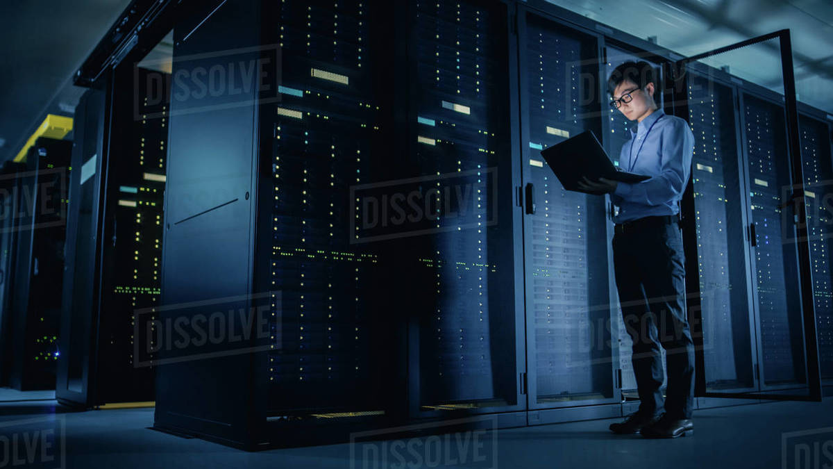 In Data Center: Male IT Technician Running Maintenance Programme on a ...