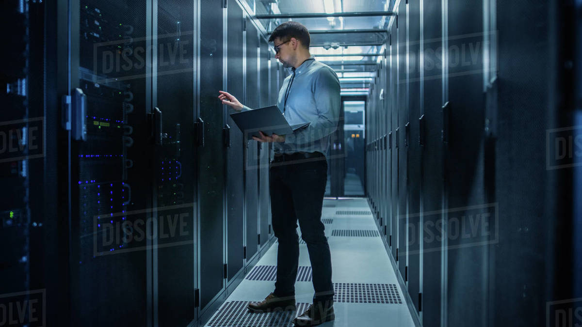 In Data Center IT Engineer Stands Before Working Server Rack Doing ...