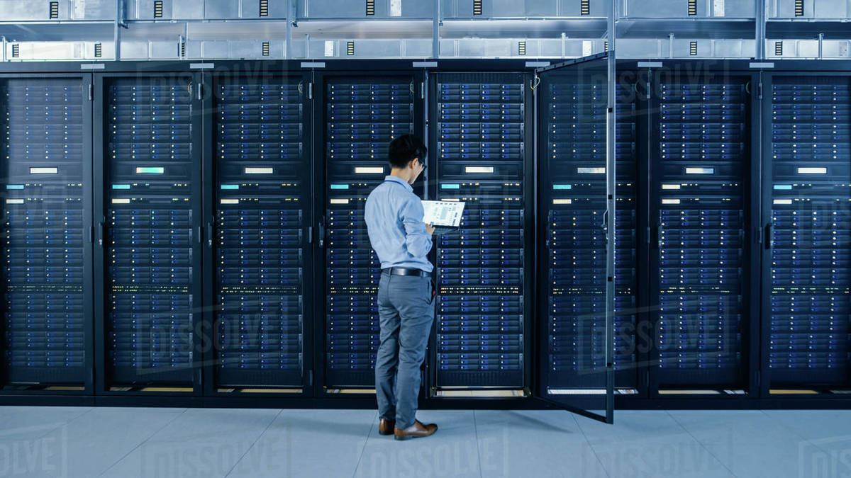 In the Modern Data Center: IT Engineer Standing Beside Open Server Rack ...