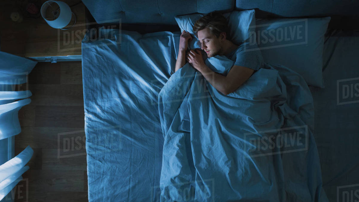 Top View of Handsome Young Man Sleeping Cozily on a Bed in His Bedroom ...