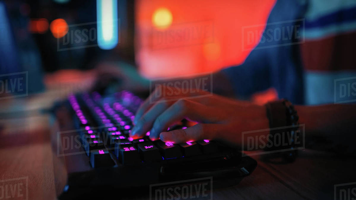 Close up hands shot showing a gamer pushing the keyboard buttons while ...