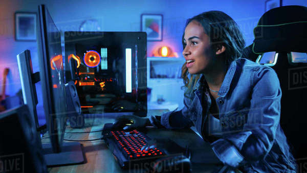 Beautiful and excited black gamer girl is playing first-person shooter ...