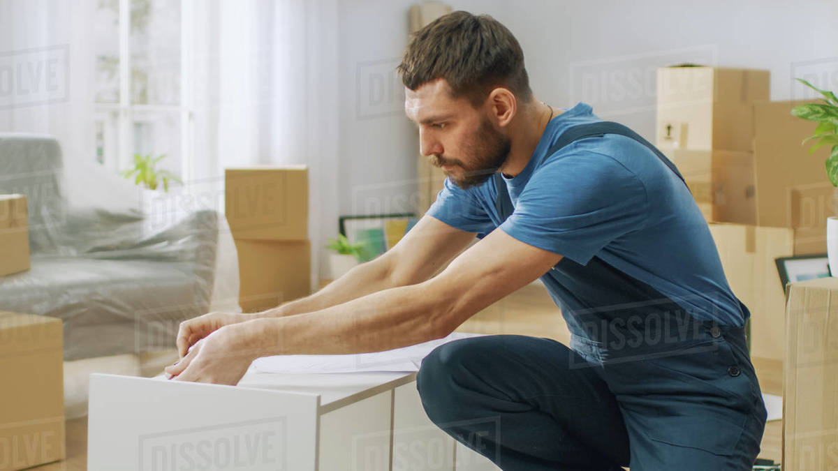 Furniture assembly worker assembles bookshelf. Professional handyman ...