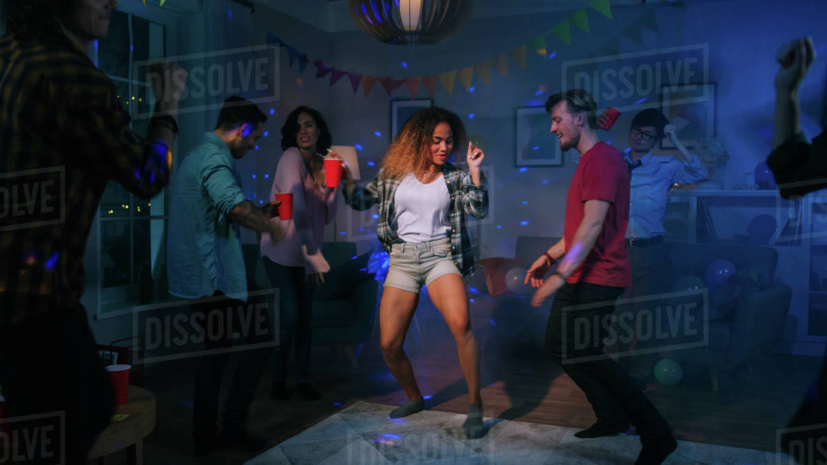 Friends dance together at a college party. - Stock Photo - Dissolve