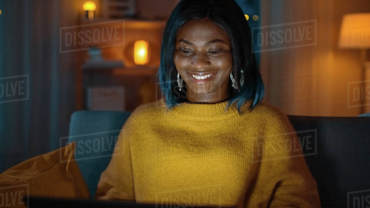 Portrait of Beautiful Black Girl Uses Computer while Relaxing on a ...