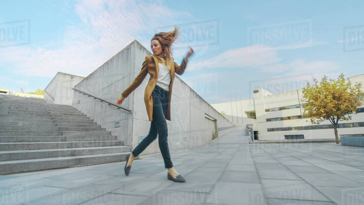 Cheerful and Happy Young Woman Actively Dancing While Walking Down the ...