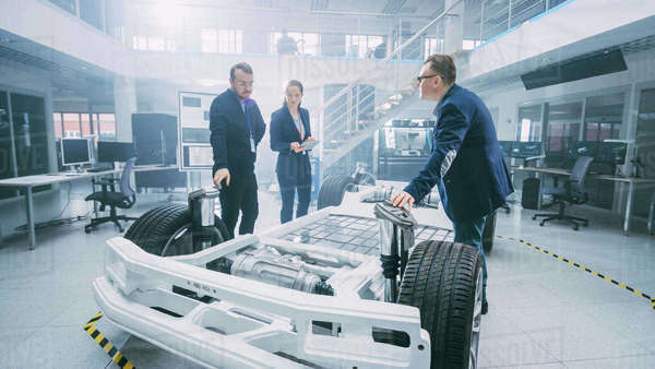 Automotive Design Engineers Talking while Working on Electric Car ...