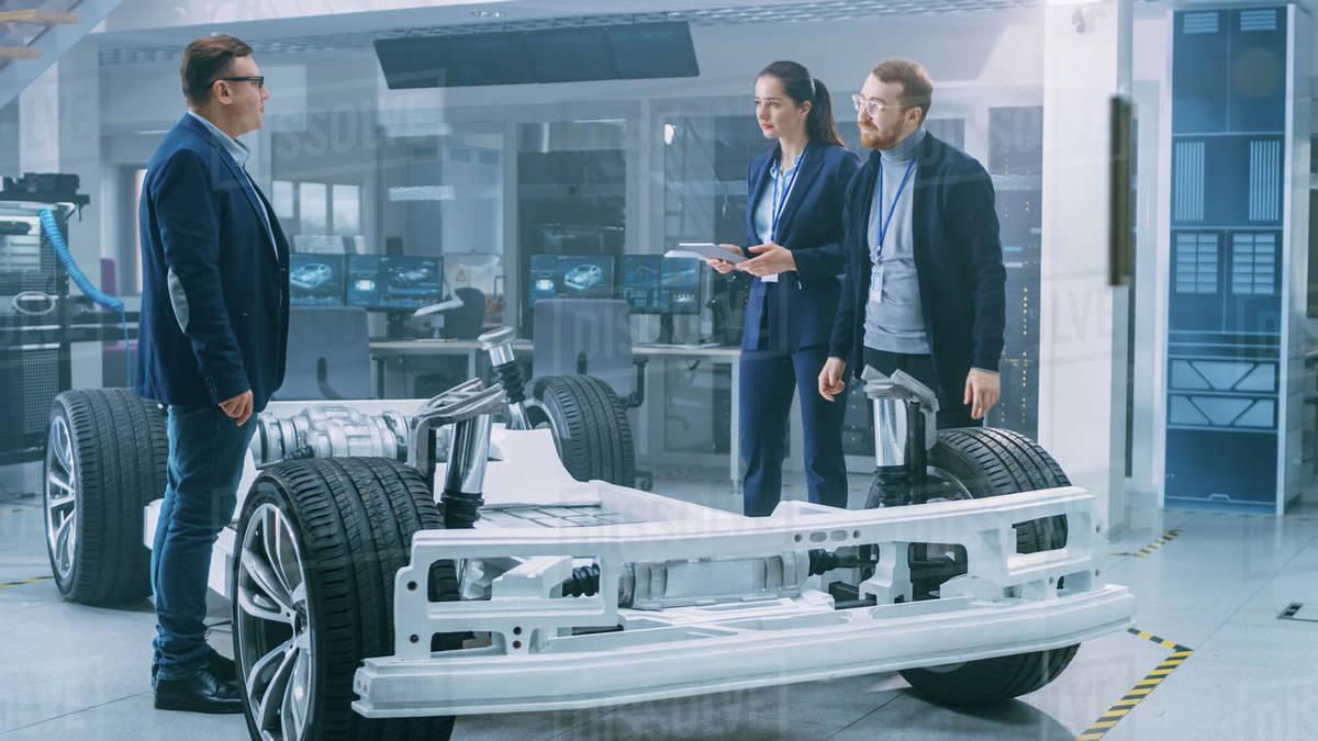 Automotive Design Engineers Talking while Working on Electric Car ...