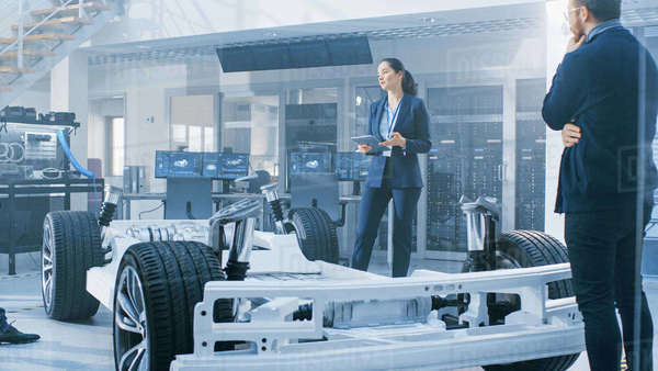 Automotive Design Engineers Talking while Working on Electric Car ...