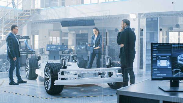 Automotive Design Engineers Talking while Working on Electric Car ...