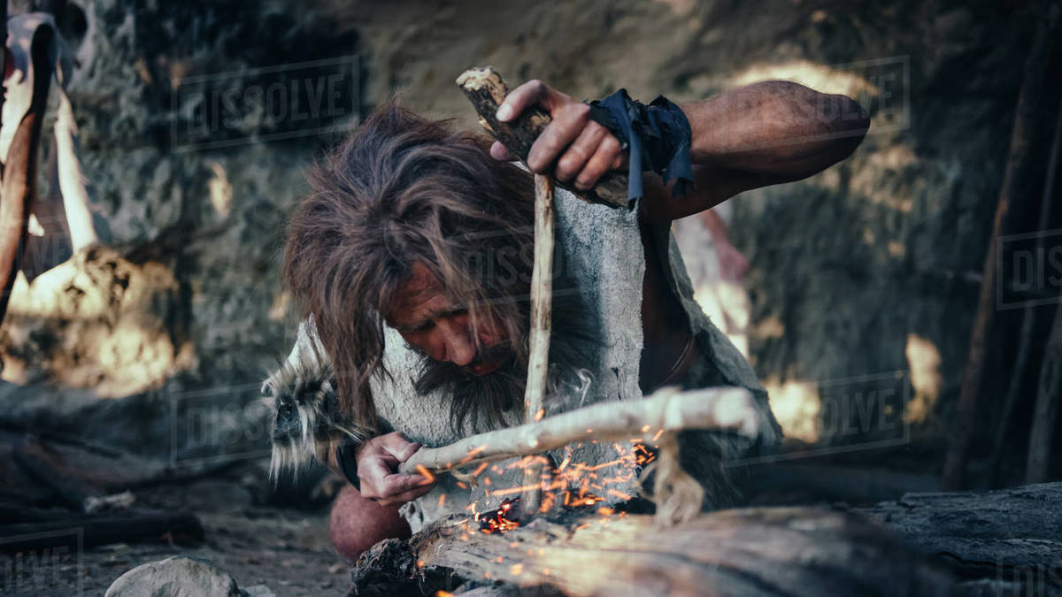 Close-up Shot of a Primeval Caveman Wearing Animal Skin Trying to make ...