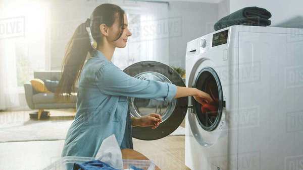 Beautiful Smiling Brunette Young Woman Sits in Front of a Washing ...