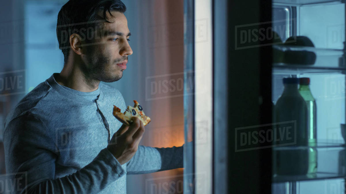 At Night in the Kitchen Handsome Attractive Young Man is Eating a ...