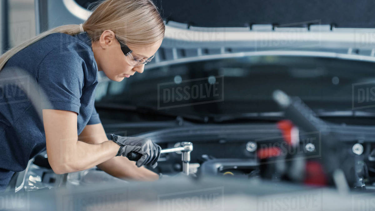 Portrait Shot of a Female Mechanic Working on a Vehicle in a Car ...