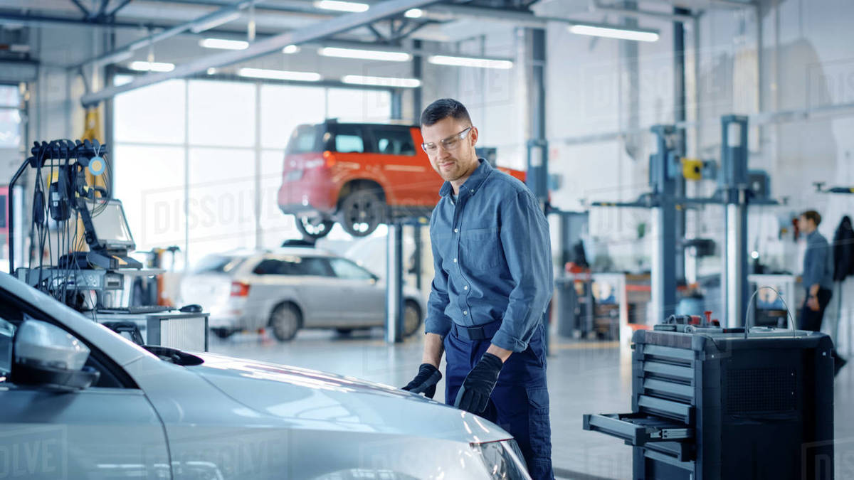 Handsome Professional Car Mechanic is Working on a Vehicle in a Service ...