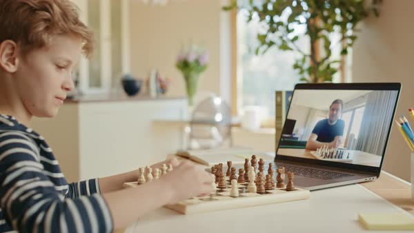 Brilliant Little Boy Playing Chess with His Chess Master, Uses Laptop ...