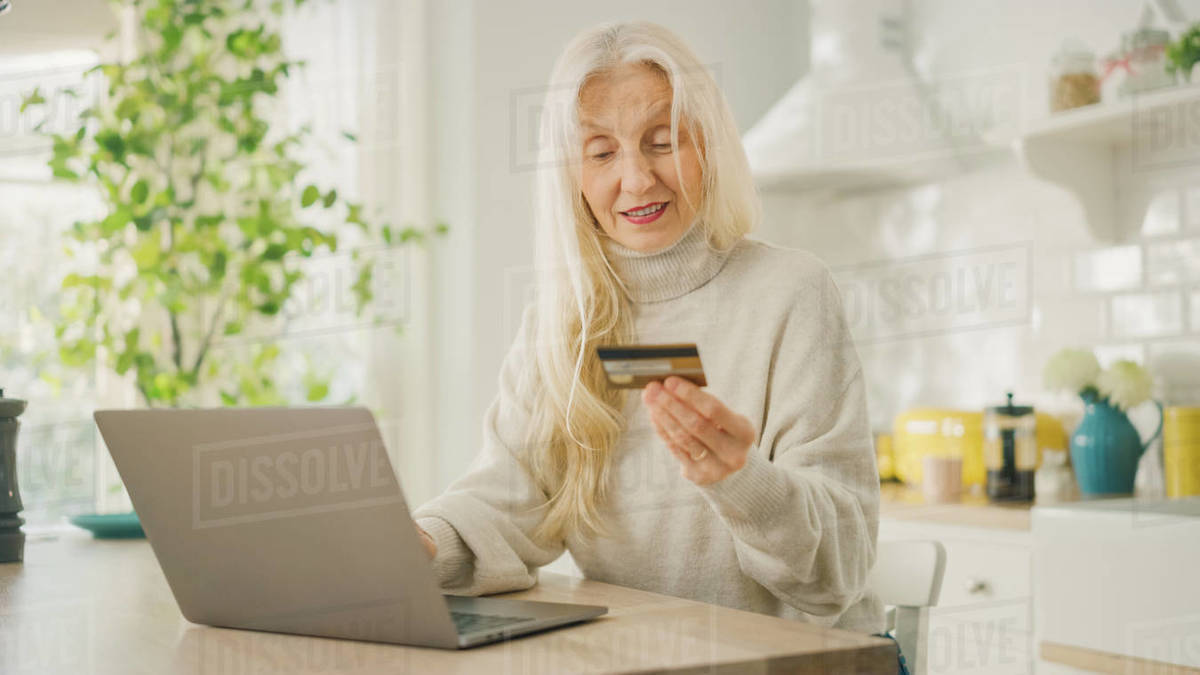 Authentic Senior Woman Using Laptop Computer in a Kitchen Room at Home ...