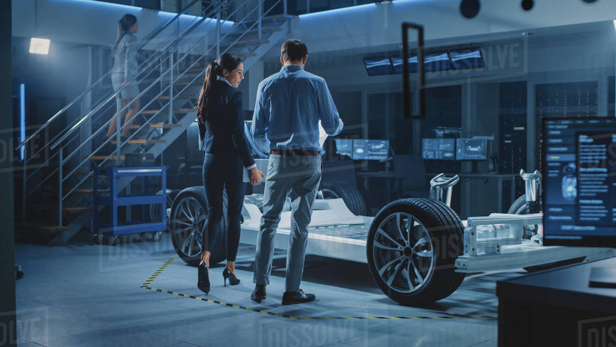 Auto Industry Design Facility: Male Chief Engineer Shows Car Prototype ...