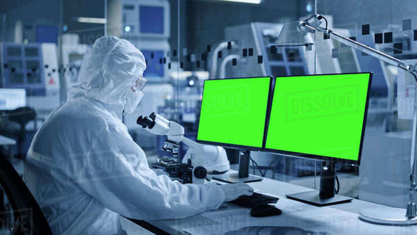Scientist wearing Coverall and Gloves Uses Microscope - Stock Photo ...