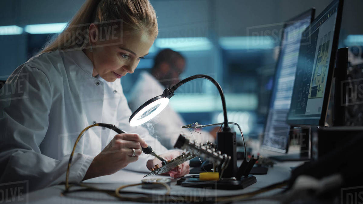 Caucasian Female Engineer Does Computer Motherboard Soldering - Royalty ...