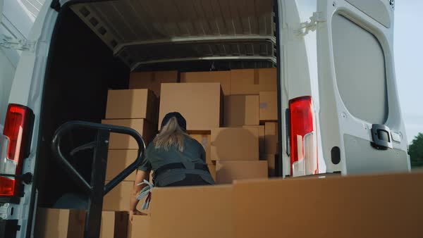 Logistics Warehouse: Female Worker Loading Delivery Truck with ...