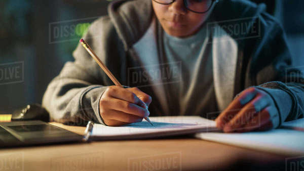 Young Teenage Black Girl Writing Down Homework in a Notebook with a ...
