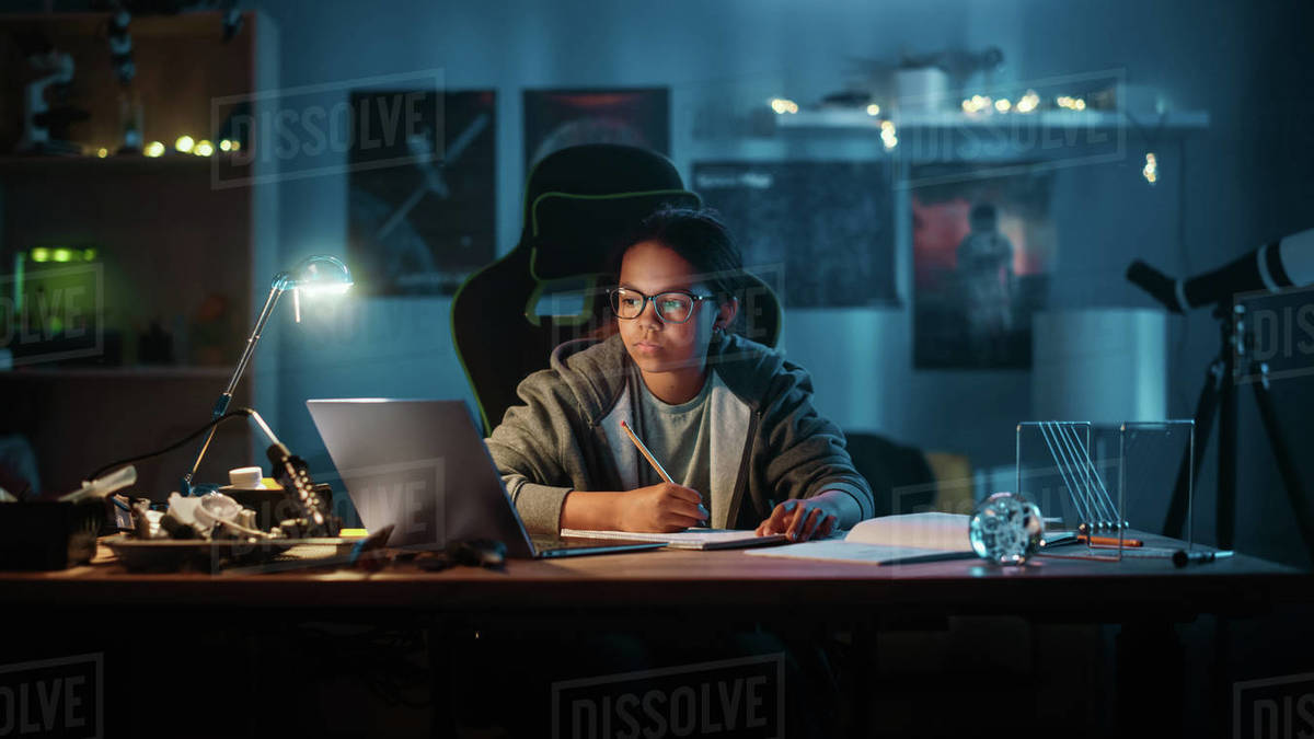 Young Teenage Girl Writing Down Homework in a Notebook with a Pencil ...