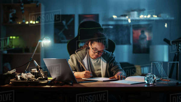 Young Teenage Black Girl Writing Down Homework in a Notebook with a ...