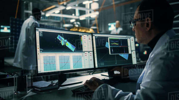 Male Engineer Uses Computer while Working on Satellite Construction ...