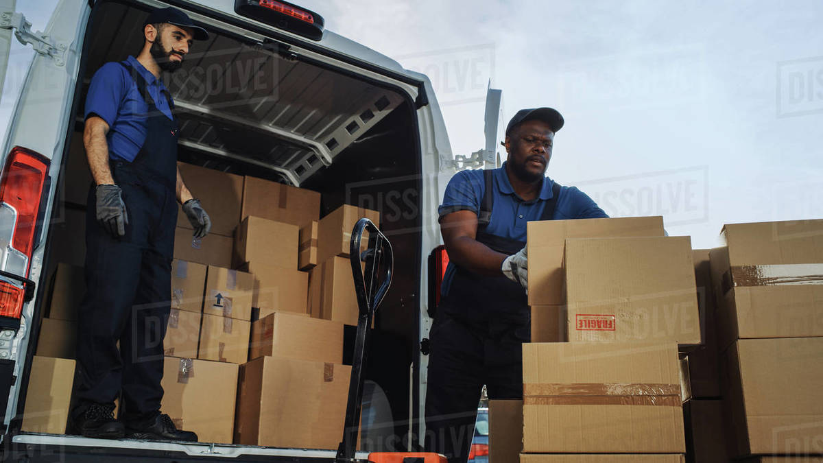 Two Workers use Hand Pallet Truck Loading Delivery Truck with Cardboard ...