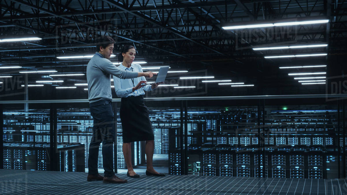 Data Center Female System Administrator and Male IT Specialist Talk ...