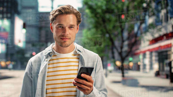 Portrait of a Young Man Wearing Casual Clothes and Using Smartphone on ...