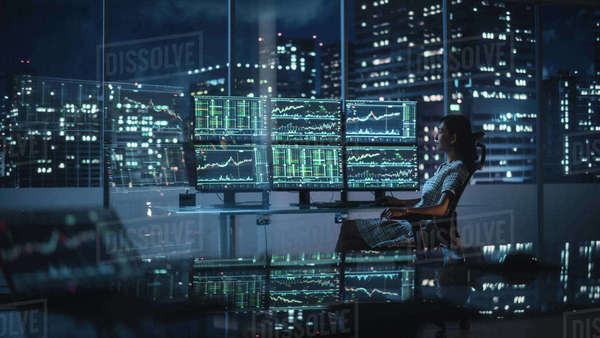 Financial Analyst Working on a Computer with Multi-Monitor Workstation ...