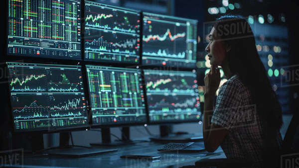 Financial Analyst Working on a Computer with Multi-Monitor Workstation ...