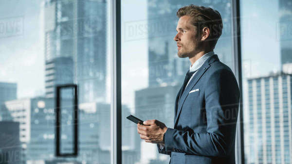 Businessman Standing Next to a Window in a Modern Office - Royalty-free ...