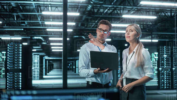 Successful Data Center IT Specialist Using Laptop Computer. Server Farm ...