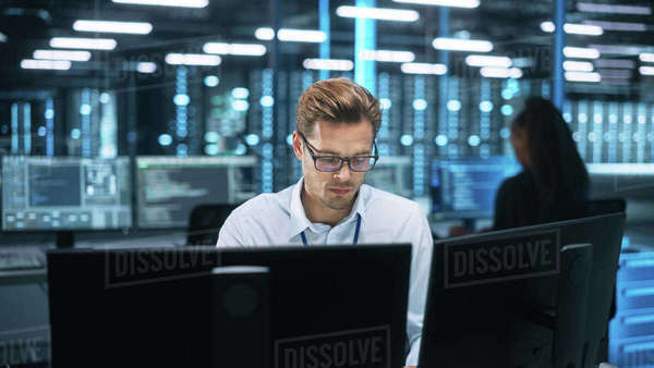 Businessman Uses Desktop Computer, while Consults with Female Project ...