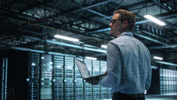 Data Center Male It Specialist Using Laptop while Working on Computer ...