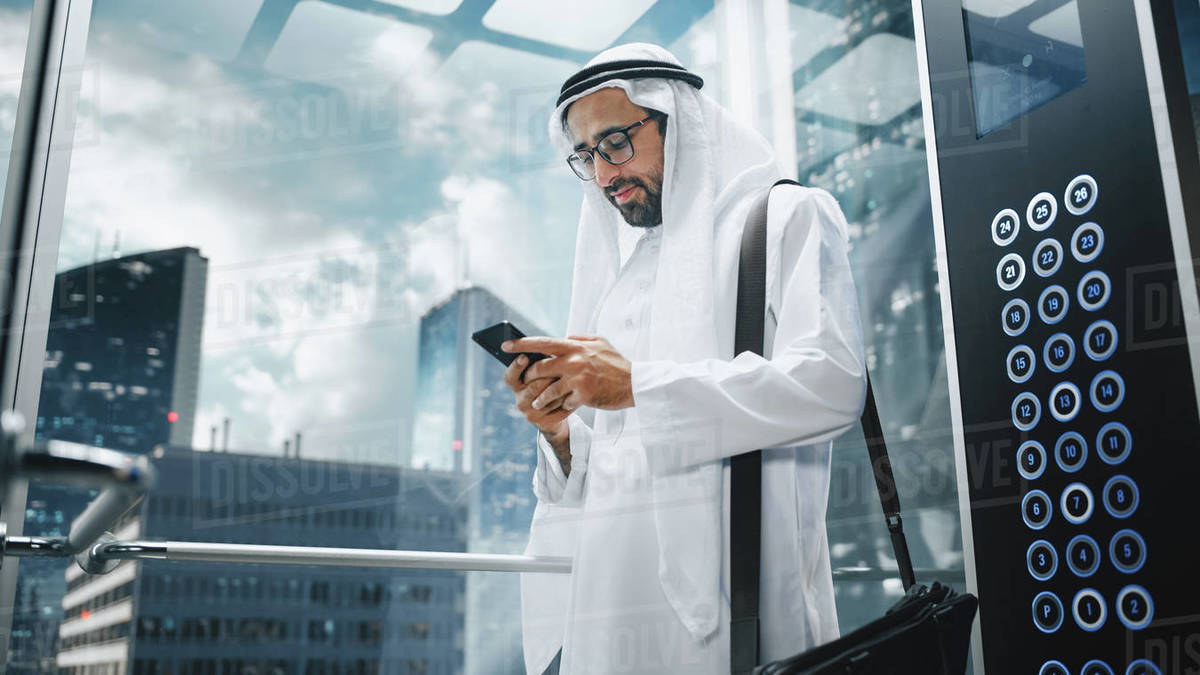 Successful Muslim Businessman in Traditional White Kandura Riding Glass ...