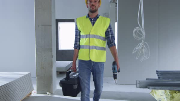 Construction worker walking inside building under construction and ...
