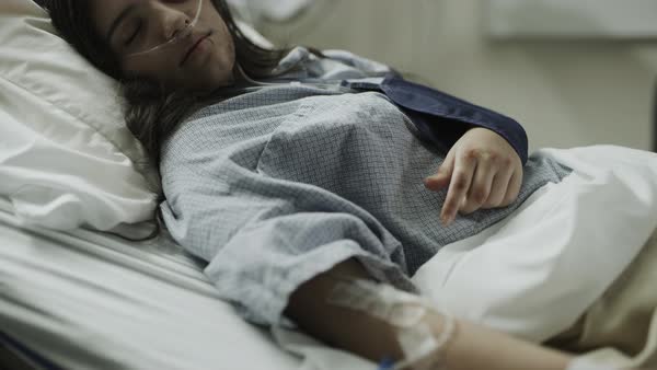 Tilt up to patient with bruised face and arm in sling sleeping in ...