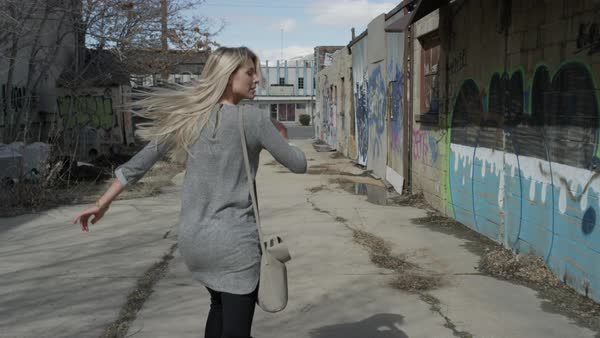 Medium slow motion tracking shot of woman running away in alley - 4K ...