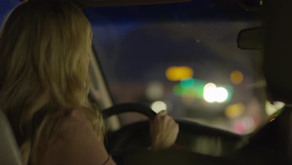 Close up rear view of woman driving car and listening to music - Stock ...