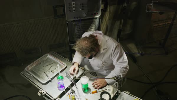 High angle view of mad scientist drinking liquid in laboratory then ...