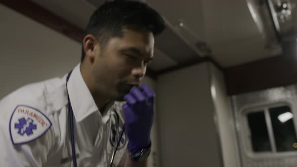 Low angle view of paramedic talking on radio in ambulance / Lehi, Utah ...
