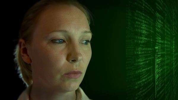 Female observer studying green lit code off to the side - Stock Video ...