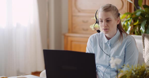 Sales representative in headset speaking to client and making video ...