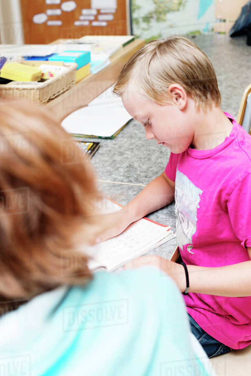Teacher checking on students work - Stock Photo - Dissolve